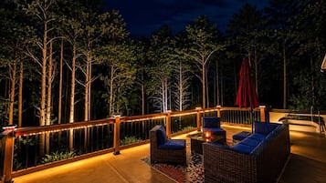 Um deck externo com guarda-corpo, área de estar e piscina.