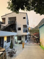 Um edifício de vários andares com varandas, área de estar externa e vista para uma encosta.