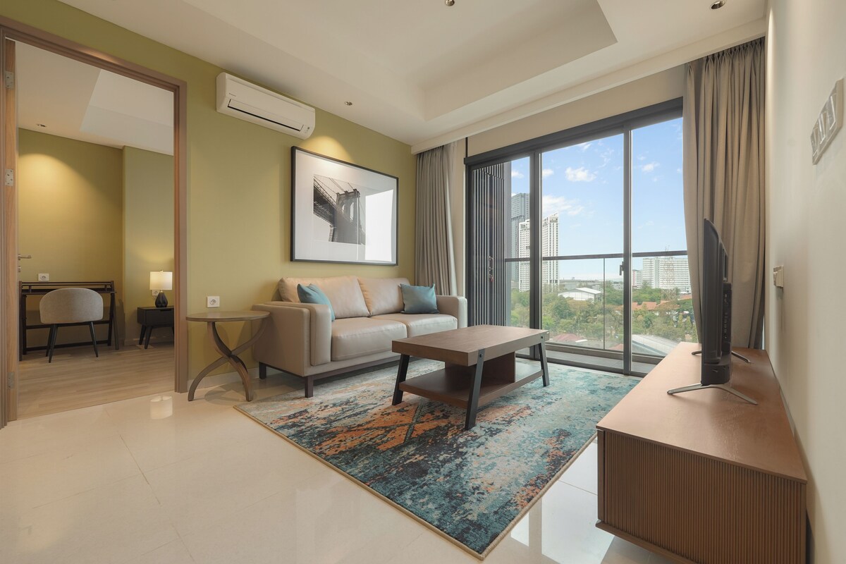 Uma sala de estar moderna com sofá, mesa de centro e uma grande janela com vista para a cidade.