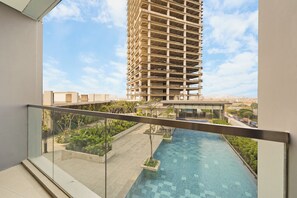 Um edifício alto com piscina e áreas verdes em primeiro plano.
