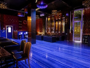 Decoração moderna com área de bar, assentos e uma grande janela com cortinas.