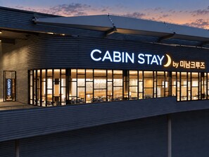 Um edifício moderno com uma placa que diz 'CABIN STAY by 마단코루조'.