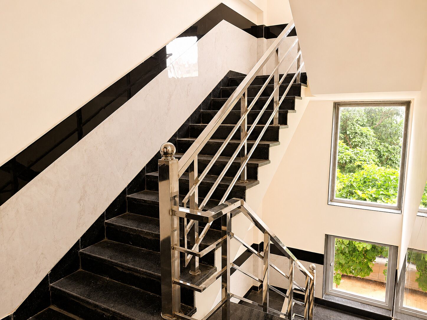 Escadaria de design moderno, com corrimão de metal e degraus pretos.