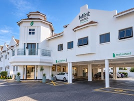 Hotel com área de recepção, restaurante e estacionamento.