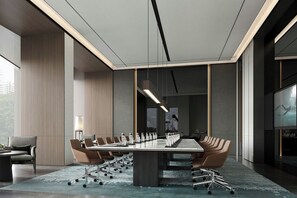 Sala de conferência com uma mesa comprida, cadeiras e vista para a cidade.