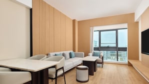 Uma sala de estar moderna com sofá, cadeiras, mesa de centro e televisão.