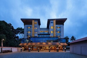 Um hotel moderno com estrutura em dois andares, grandes janelas e área de entrada coberta.