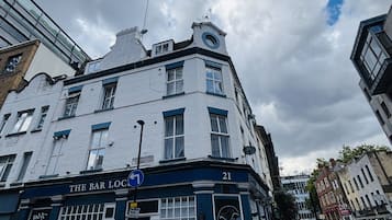 Um edifício de esquina com um bar chamado 'The Bar Loc' no andar térreo.
