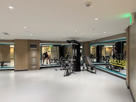 Uma academia com equipamentos de ginástica, espelhos e um design moderno e limpo.