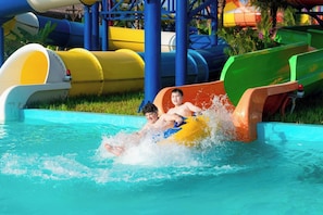 Um parque aquático com um tobogã e uma piscina.