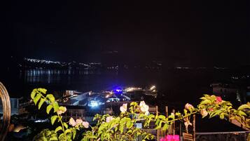 Vista noturna de um horizonte urbano com edifícios e uma ponte ao longe.