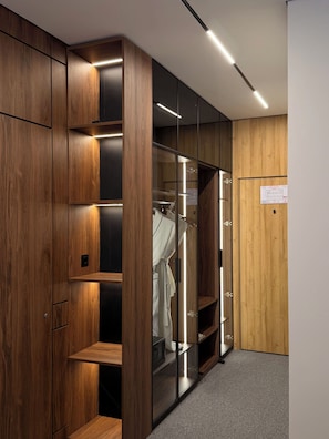 Um closet amplo com prateleiras de madeira, um espelho e um cabideiro.