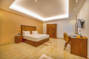 Quarto moderno com cama, mesas de cabeceira, guarda-roupa, escrivaninha e uma cadeira.