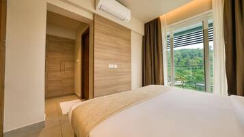 Quarto de hotel com cama, ar condicionado, porta deslizante e varanda com vista para o verde.