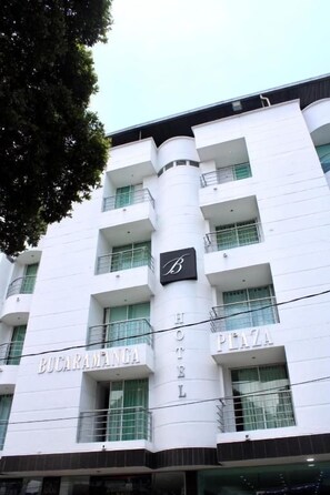 Um hotel com vários andares e varandas, com um logo 'B' em destaque e a placa 'BUCARAMANGA HOTEL' na fachada.
