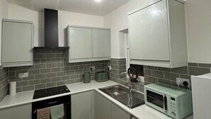 Um frigorífico, um micro-ondas, um forno, uma placa de cozinha 
