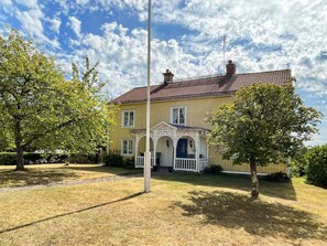 Uma casa de dois andares com varanda e chaminé.
