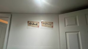 Duas placas numa parede: uma acolhendo hóspedes do Airbnb e outra pedindo para manter o volume baixo por respeito aos vizinhos.