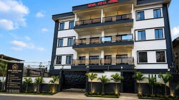 Um hotel com vários andares, varandas, salão de conferências e uma casa de hóspedes.