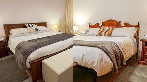Uma cama de casal com cabeceira de madeira, mesa de cabeceira e criado-mudo.