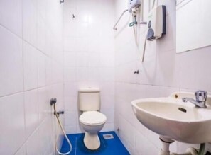 Casa de banho pequena com sanita, lavatório e chuveiro.