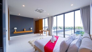 Quarto de hotel moderno com uma cama grande, uma escrivaninha e vista para a cidade.