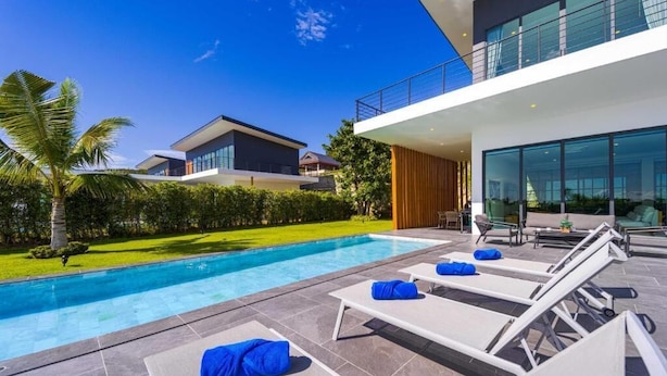 Uma área moderna com piscina ao ar livre, espreguiçadeiras e vista desimpedida para a paisagem circundante.