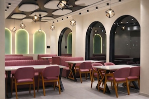 Interior de restaurante com cabines, mesas e cadeiras.