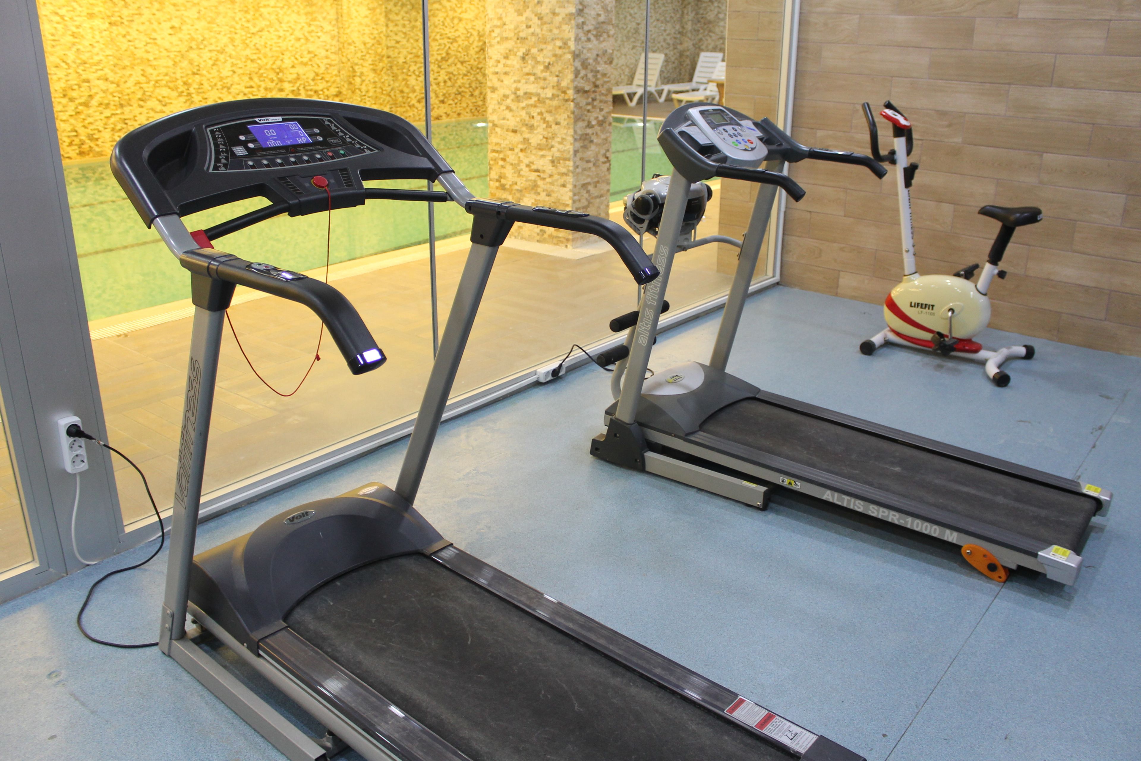 Uma academia equipada com esteiras e bicicleta ergométrica.
