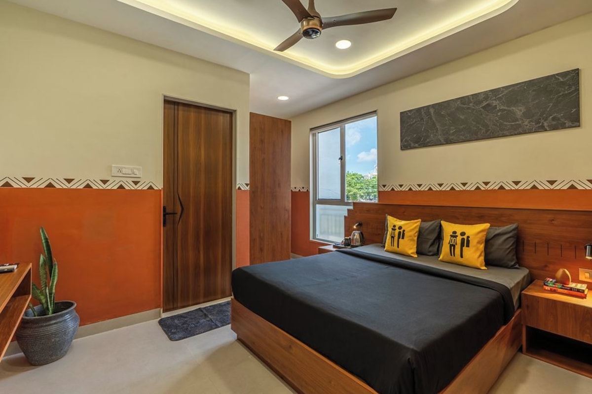 Quarto com cama, ventoinha no teto, janela e porta.