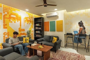 Uma sala de estar moderna com um sofá, uma mesa de centro e uma estante de livros.