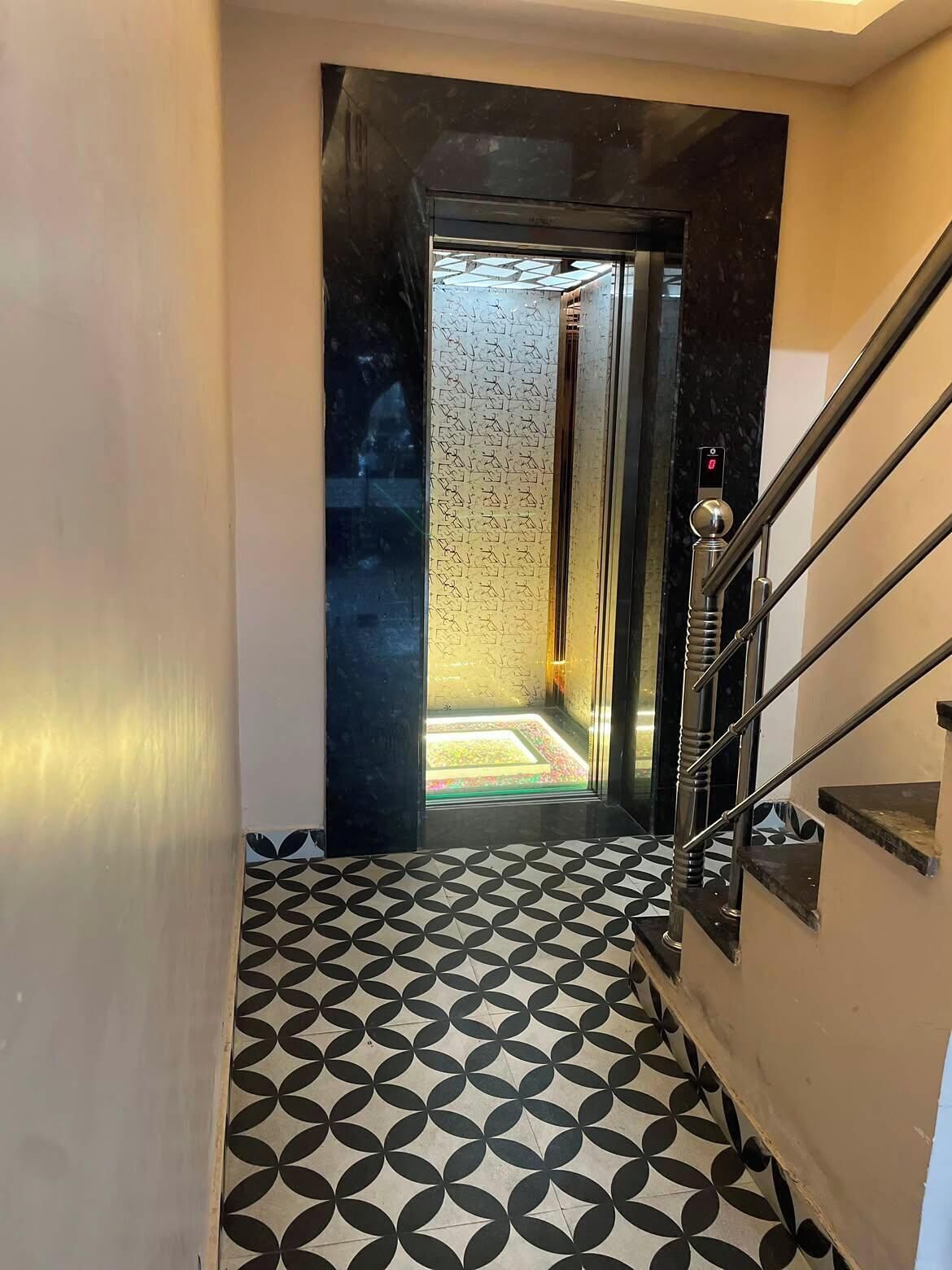 Corredor com piso estampado que leva a um elevador.