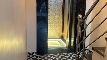 Corredor com piso estampado que leva a um elevador.