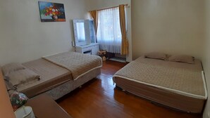 Quarto com duas camas, uma toucador com espelho, um quadro na parede e uma janela com cortinas.