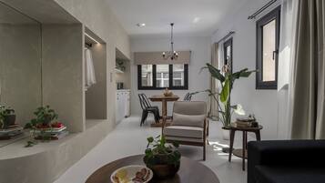 Uma sala de estar moderna com área de refeições, cozinha ao fundo e uma grande janela com cortinas.