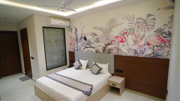 Quarto com cama, mesa de cabeceira e parede decorada com um mural floral.
