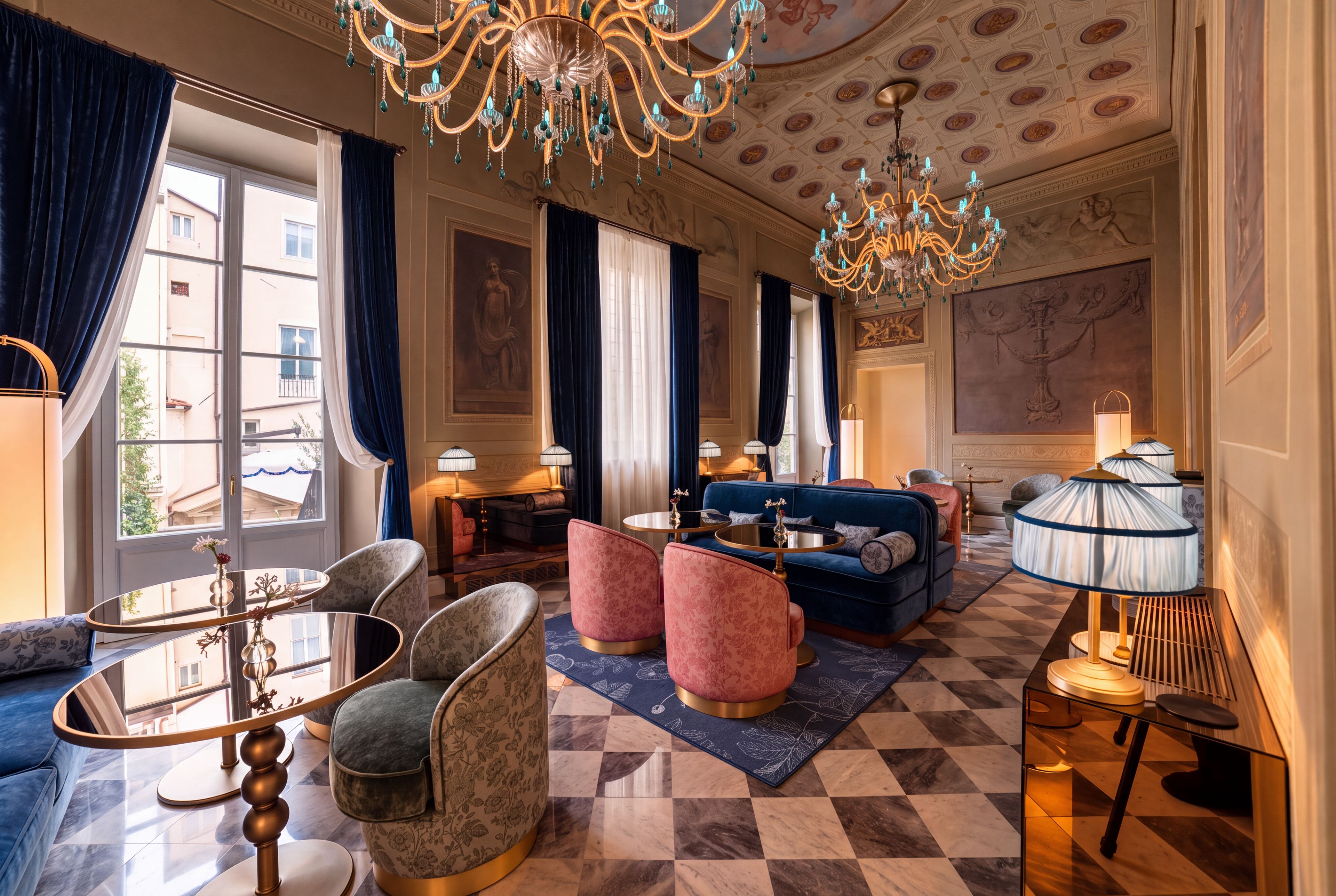 Um hall de hotel luxuoso com piso xadrez, móveis elegantes e lustres elaborados.