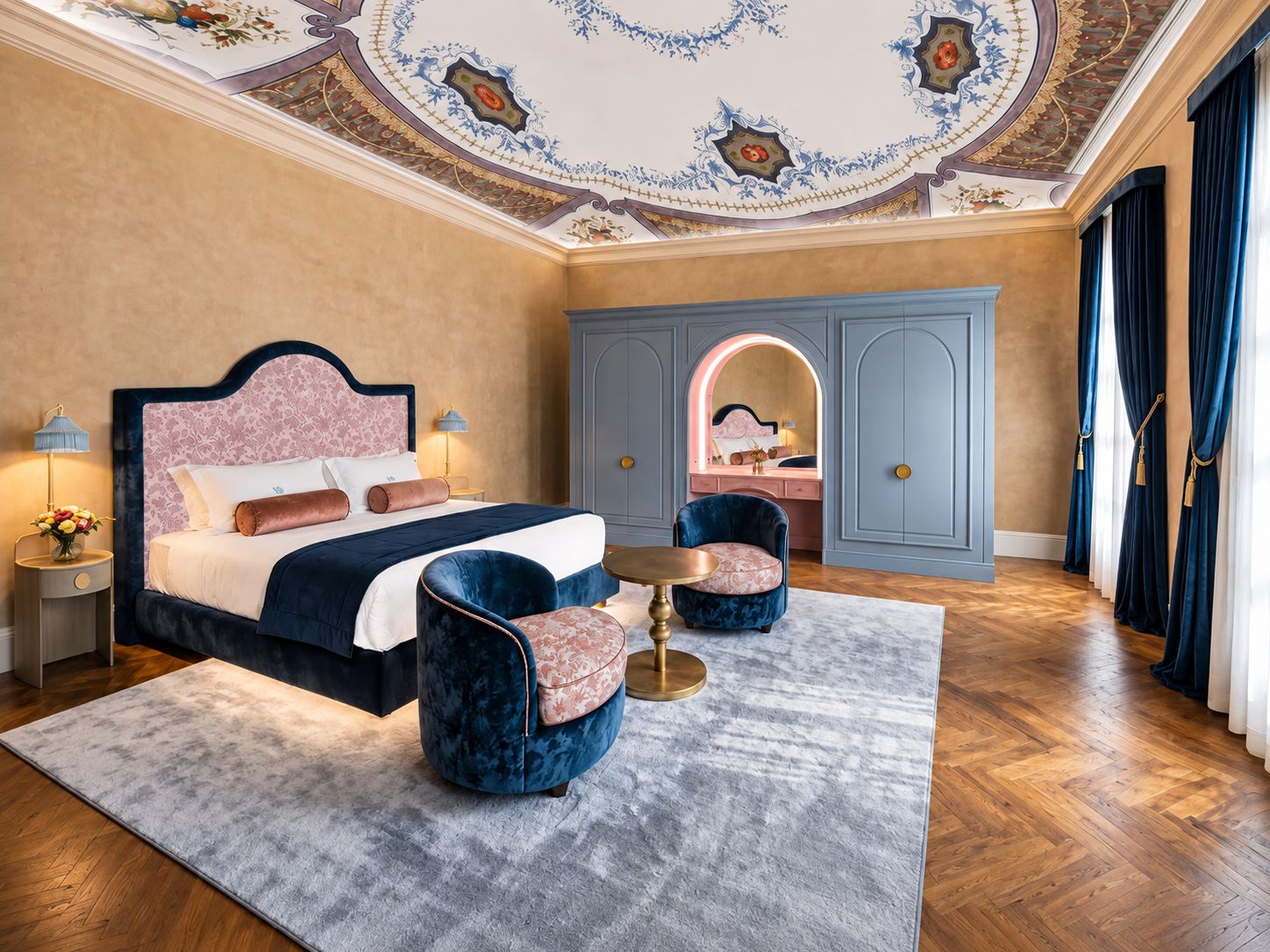 Quarto com cama, duas poltronas, escrivaninha e guarda-roupa.