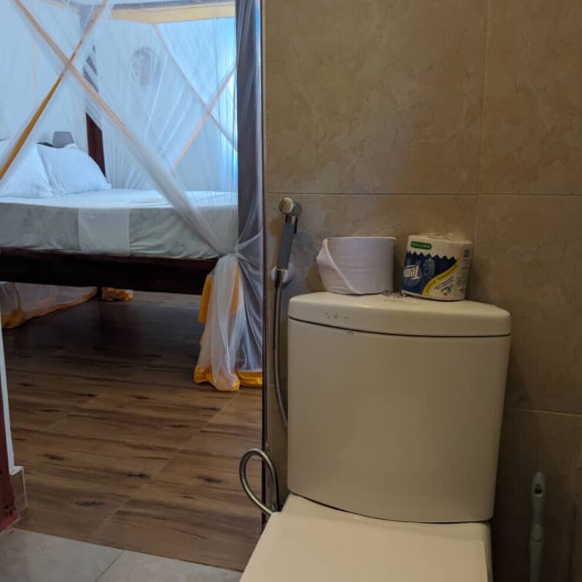 Um banheiro com vaso sanitário, rolo de papel higiênico e bidê.
