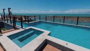 Piscina com vista para a praia e o oceano.