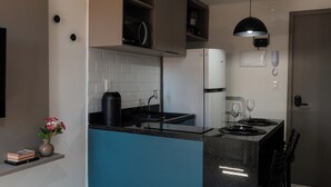 Uma cozinha moderna com uma ilha azul, eletrodomésticos de aço inoxidável e micro-ondas embutido.