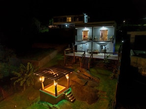 Um edifício de dois andares com varanda e área de estar coberta ao ar livre.