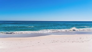 Uma praia com céu claro e mar calmo.