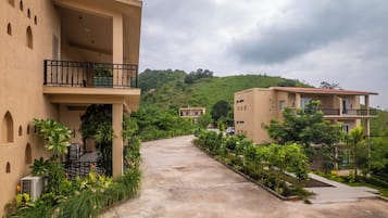 Um bairro residencial com vários edifícios, um caminho pavimentado e vegetação exuberante.