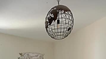 Quarto com cama, globo pendurado no teto e ilustração de um porco na parede.