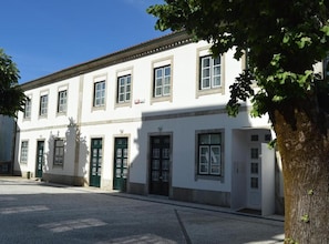 Um edifício com fachada simétrica, várias janelas e portas.