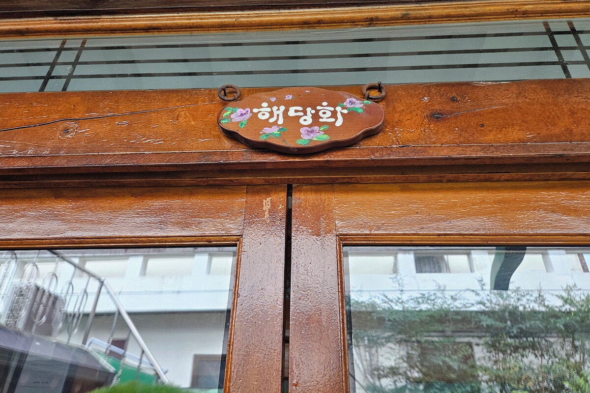 Uma porta de madeira com uma placa acima.