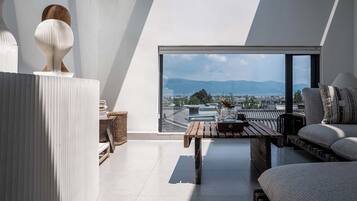 Uma sala de estar moderna com uma janela ampla, uma mesa de madeira e um sofá.