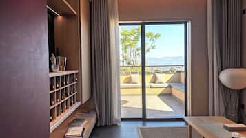 Quarto moderno com espaço para vinhos embutido, área de estar com vista e porta de vidro deslizante grande.