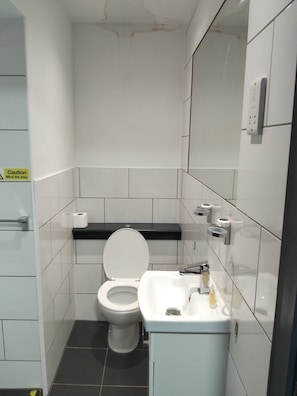 Um banheiro pequeno e moderno, com vaso sanitário, pia e espelho.